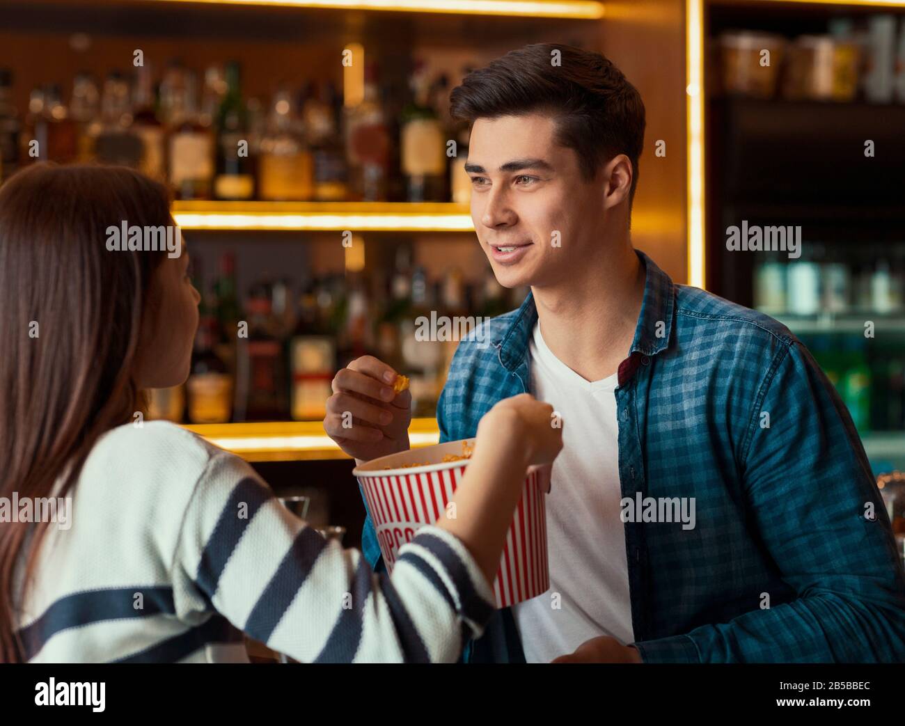 Movie night. Lovely young couple eating popcorn in cinema cafeteria ...