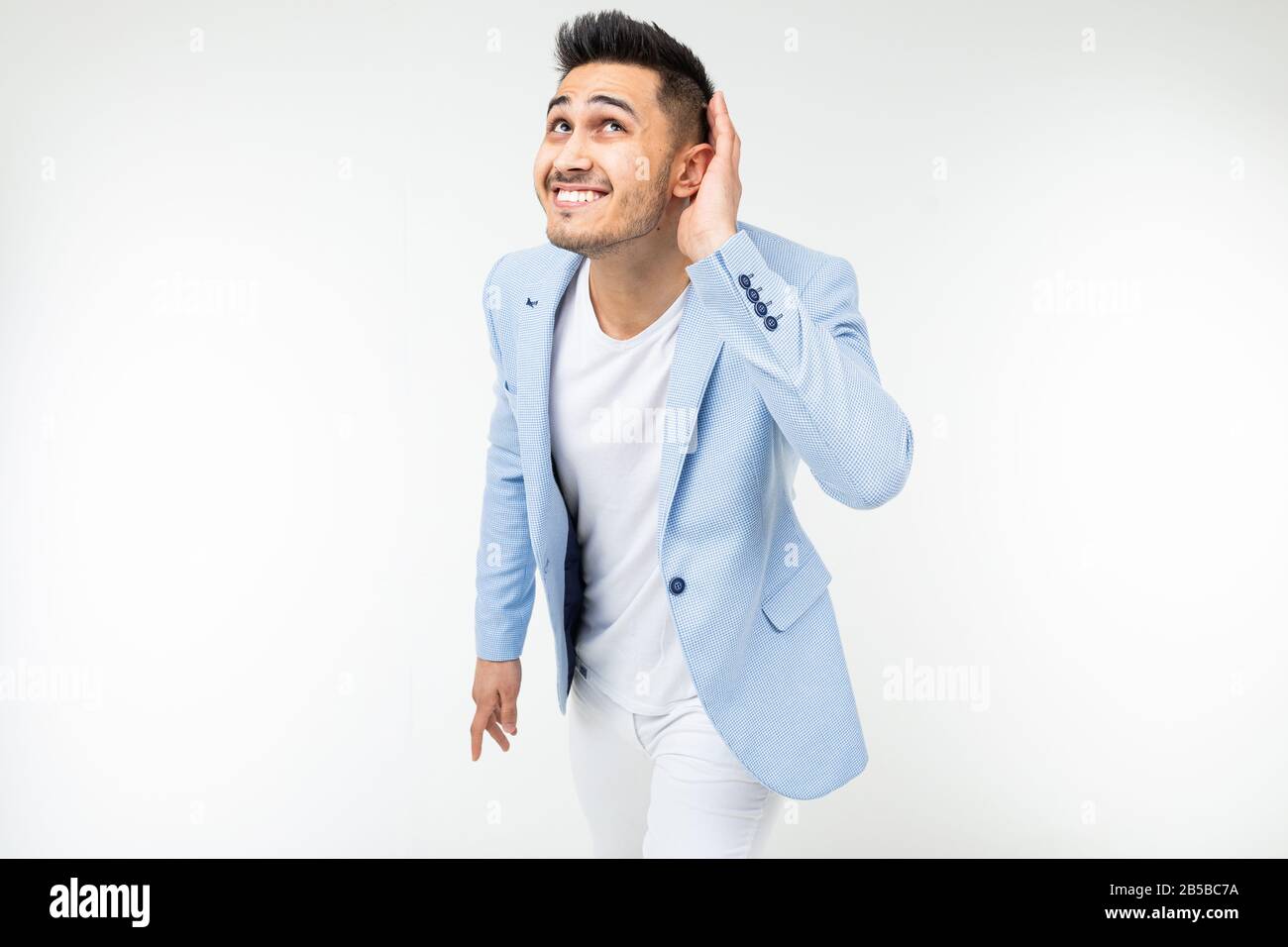 young guy in a blue jacket overhears a conversation on a white ...