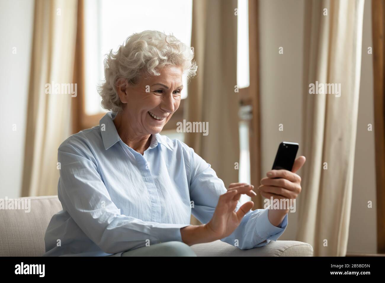 Smiling 60s woman talk on video call on cell Stock Photo - Alamy