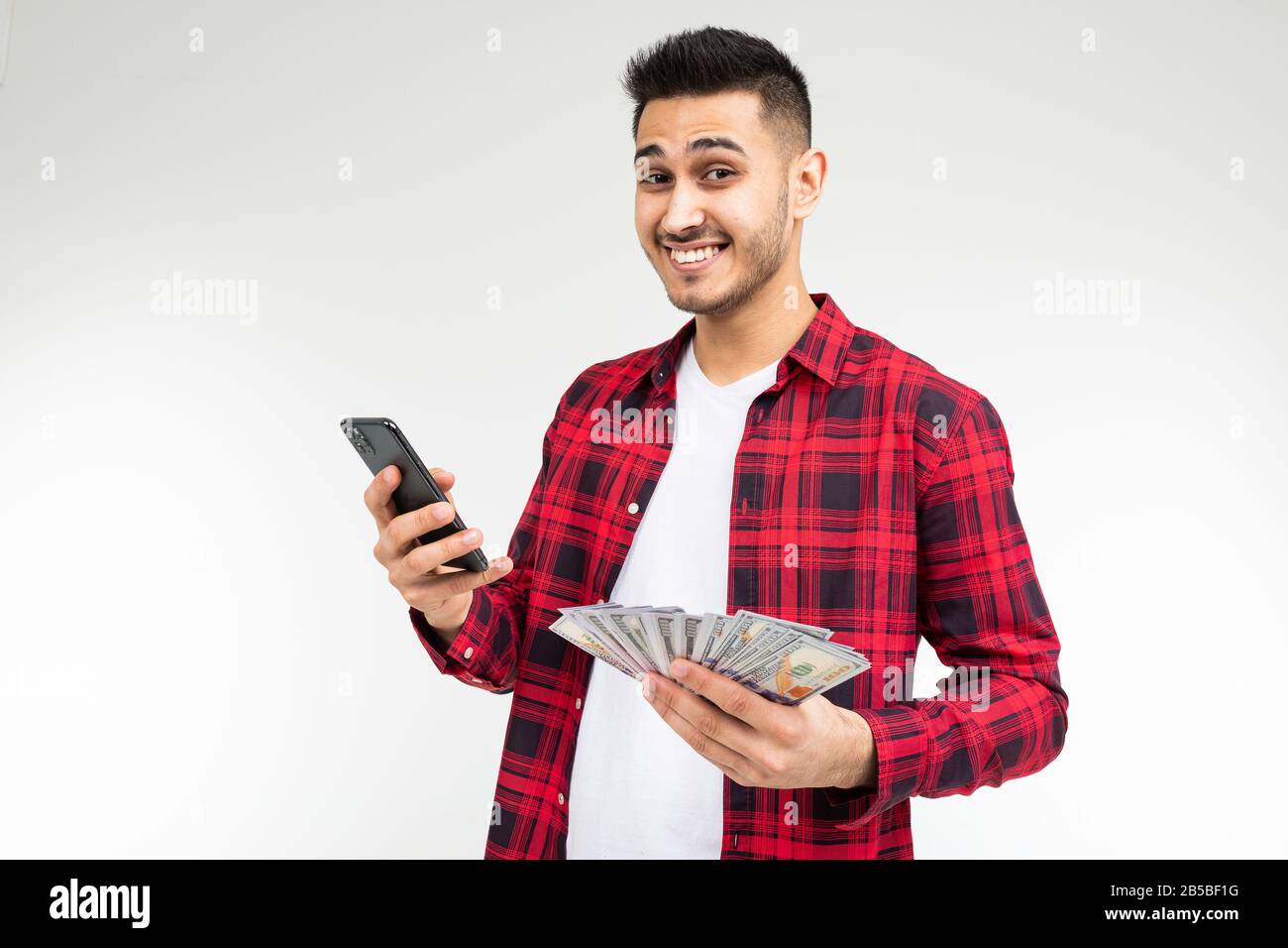 portrait of a cute guy with a bunch of money talking on the phone on a ...