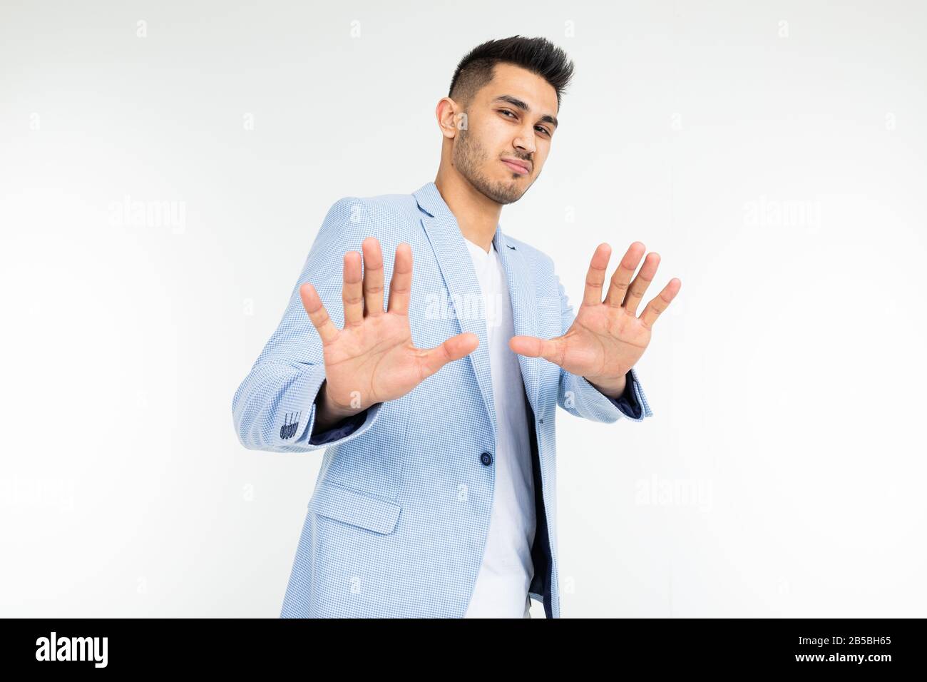 serious man in a classic image shows his palms on a white background ...