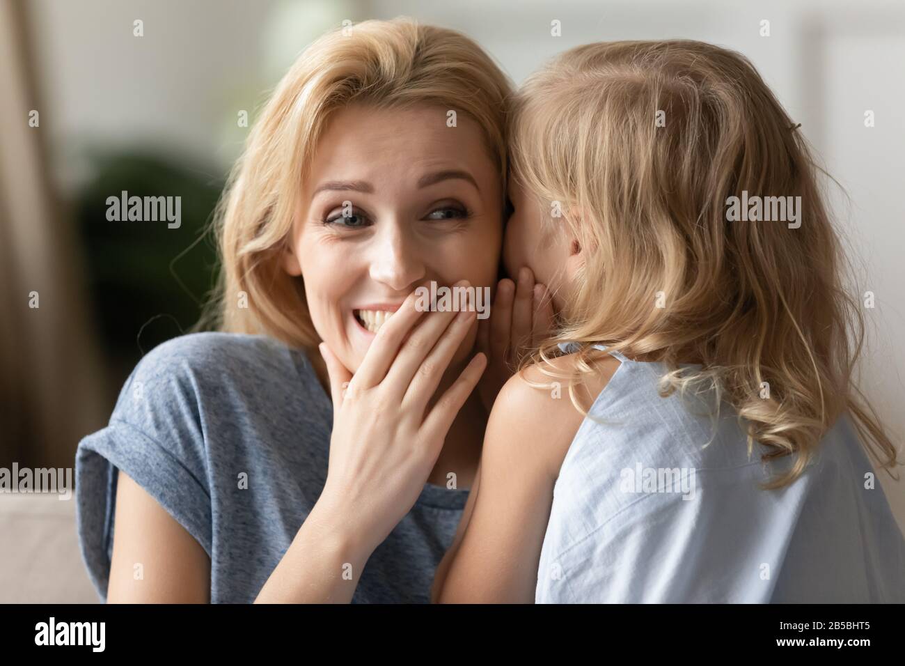 Little girl share secret with young mother Stock Photo - Alamy
