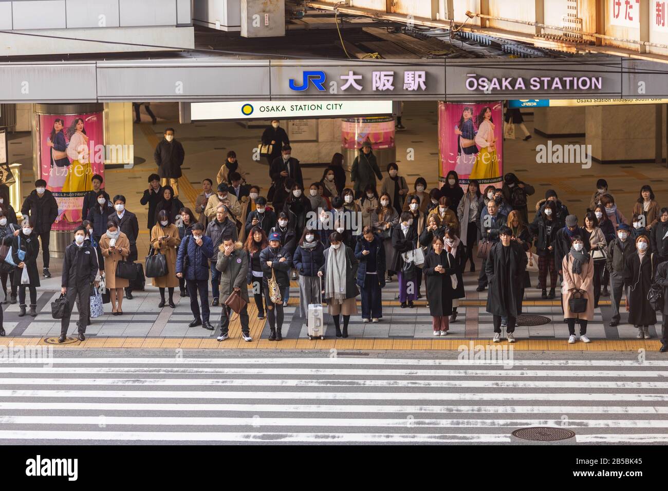 Osaka, Japan - March 4, 2020: Crowd of people wearing masks wait to ...
