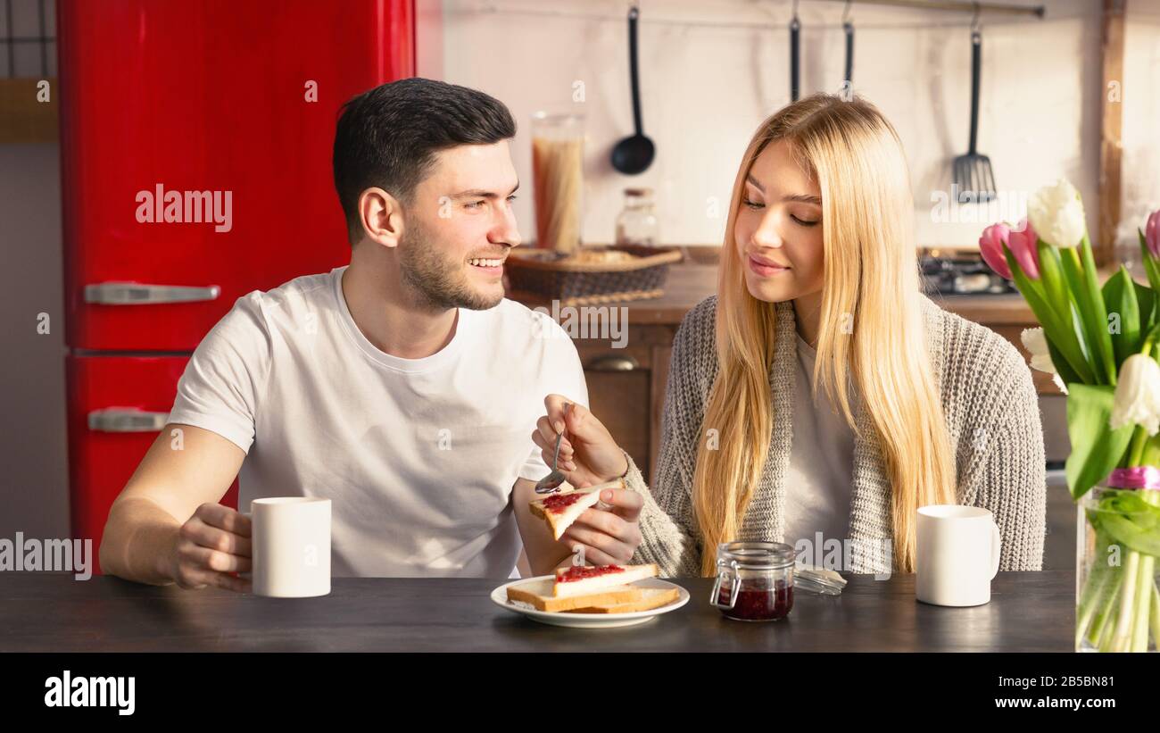 Romantic morning. Lovely young couple eating breakfast together in ...