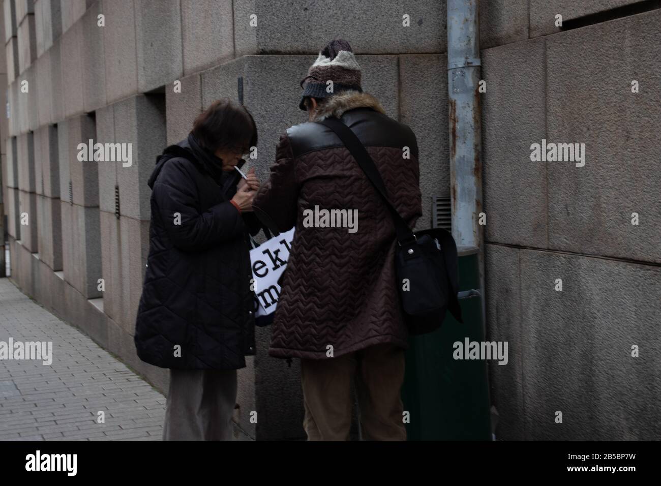 Helsinki, Finland - 3 March 2020: Poor people smoking on street ...