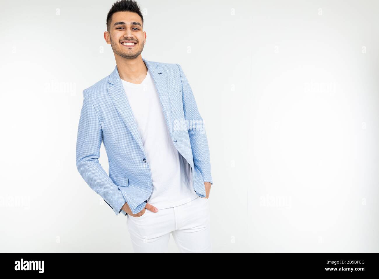 handsome guy in a blue jacket with a beautiful smile tucked his hands ...