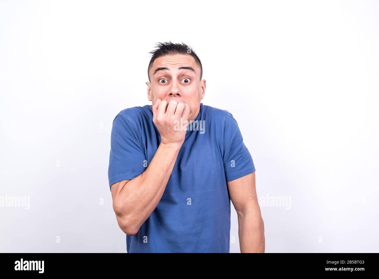 nervous man eating his nails. white background, medium shot Stock Photo ...