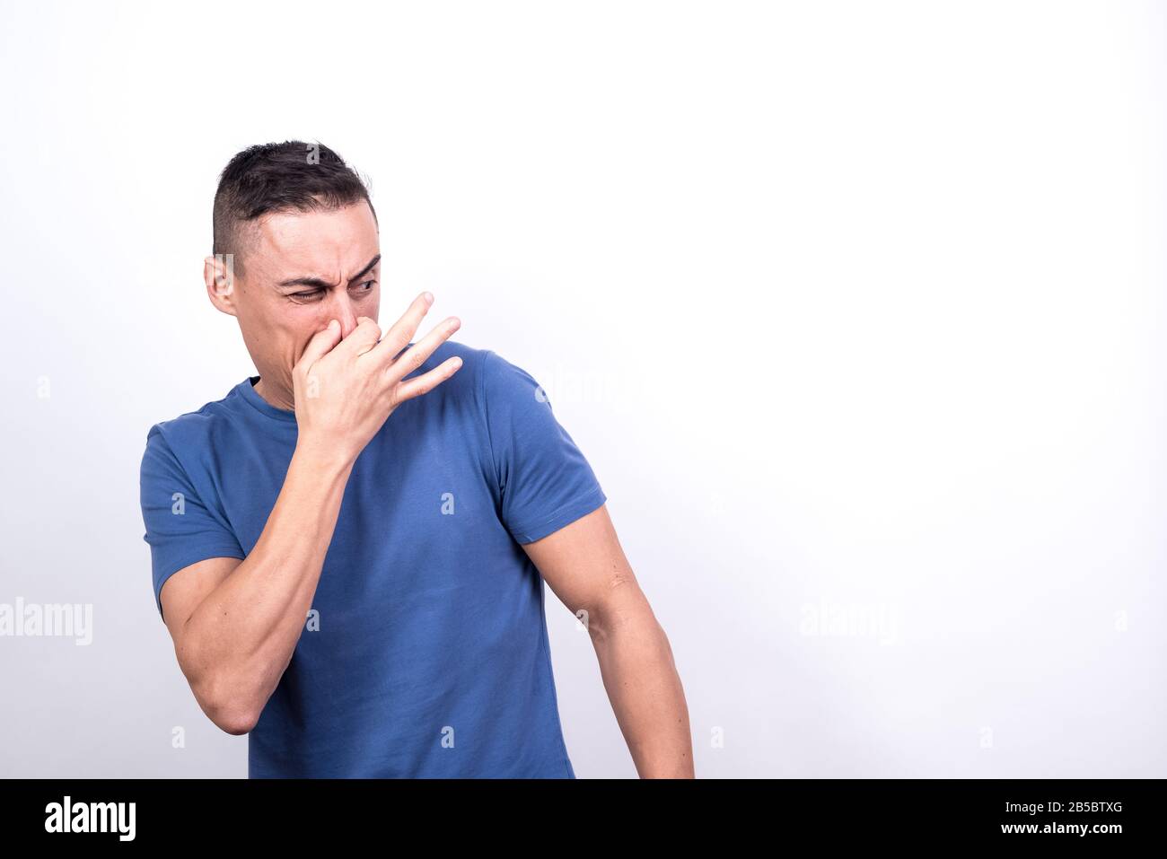 Man disgusted by bad smell. White background, Medium shot Stock Photo ...