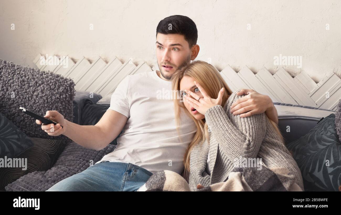Terrified young couple watching scary movie at home Stock Photo - Alamy