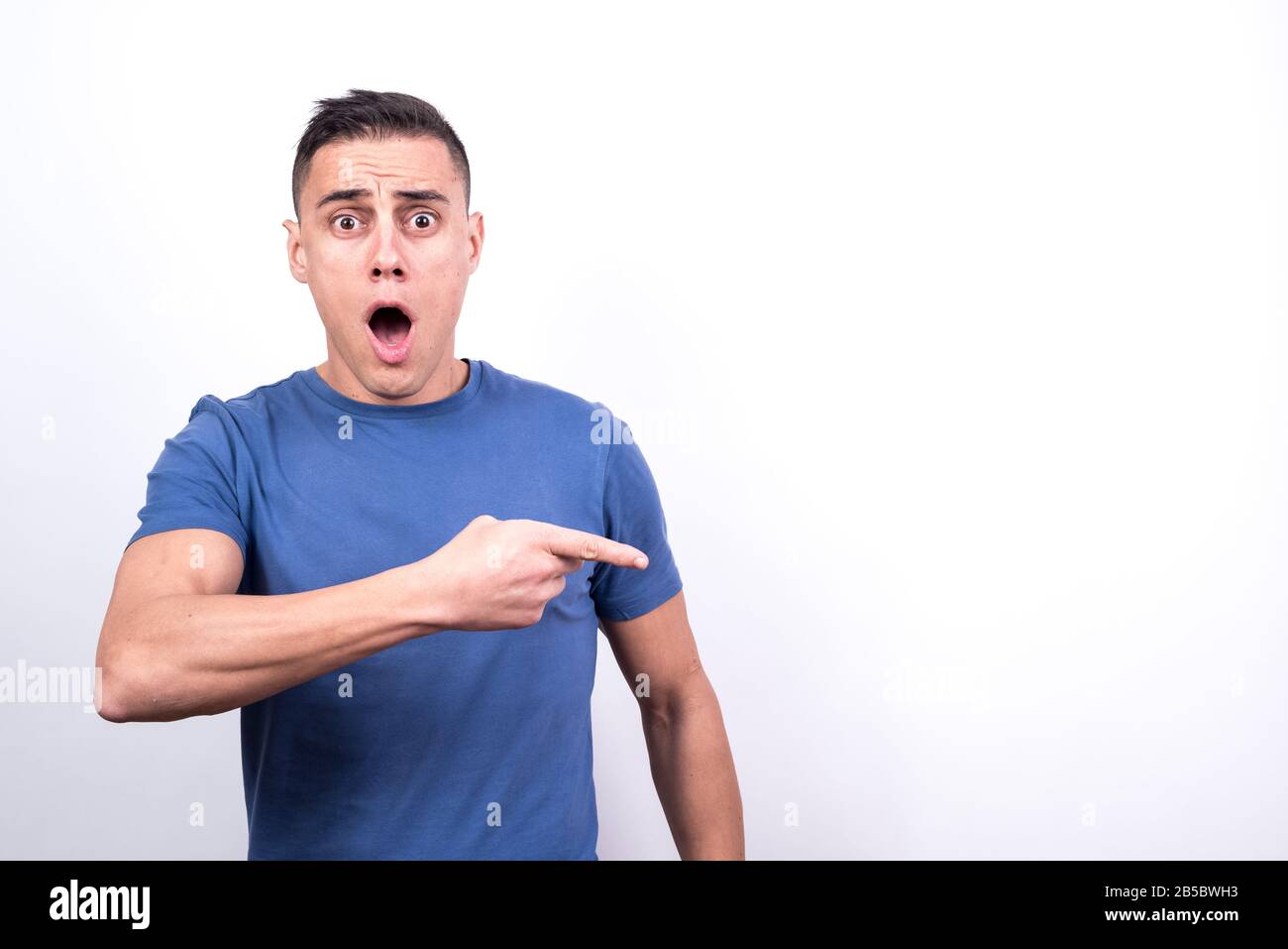 Surprised man pointing to copy space. White background, Medium shot ...