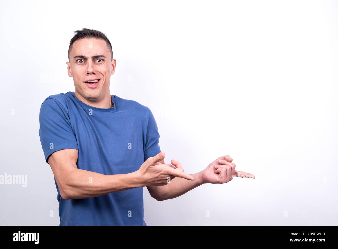 Surprised man pointing to copy space. White background, Medium shot ...