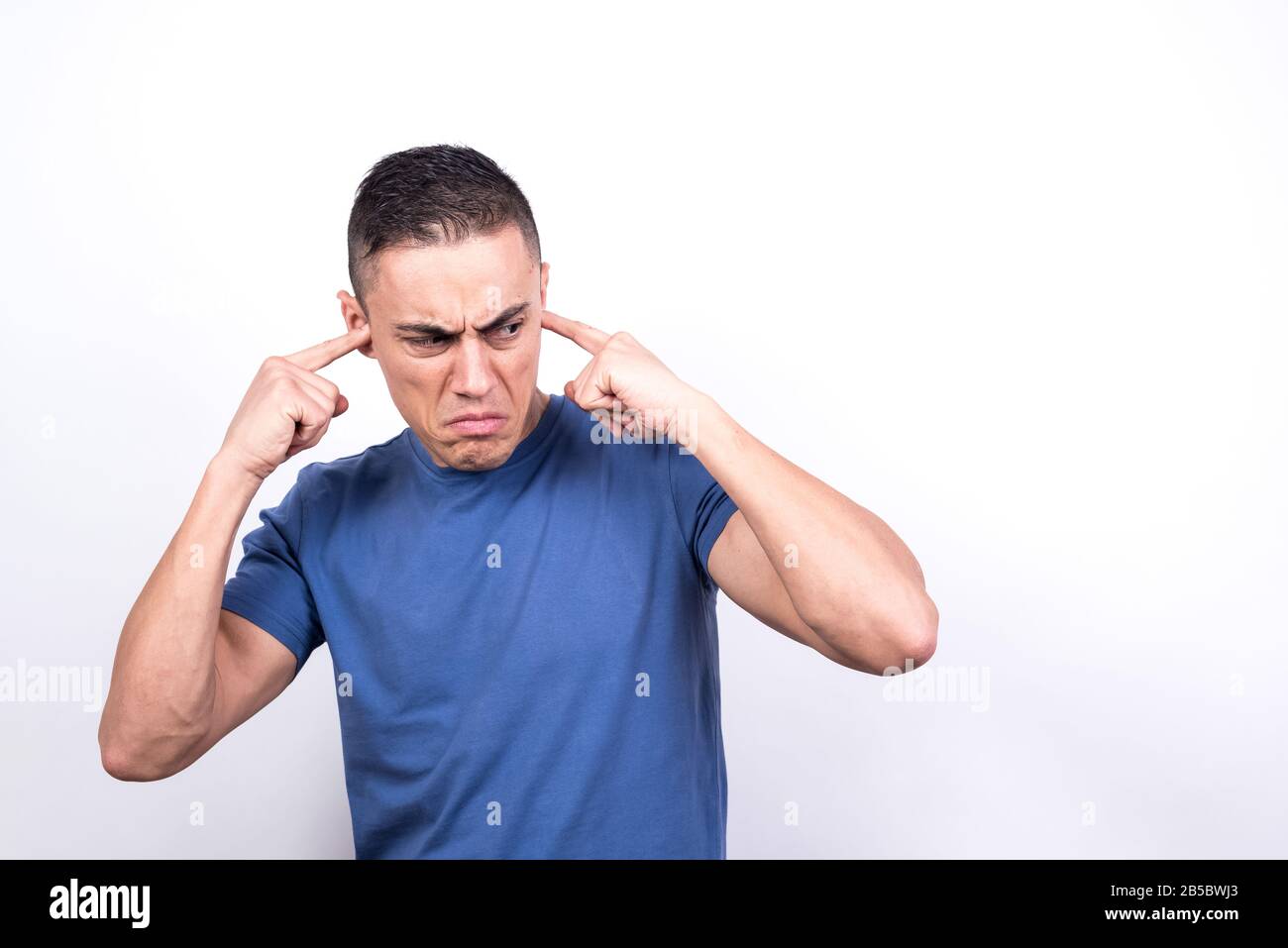 Man disgusted by noise. White background, Medium shot Stock Photo - Alamy