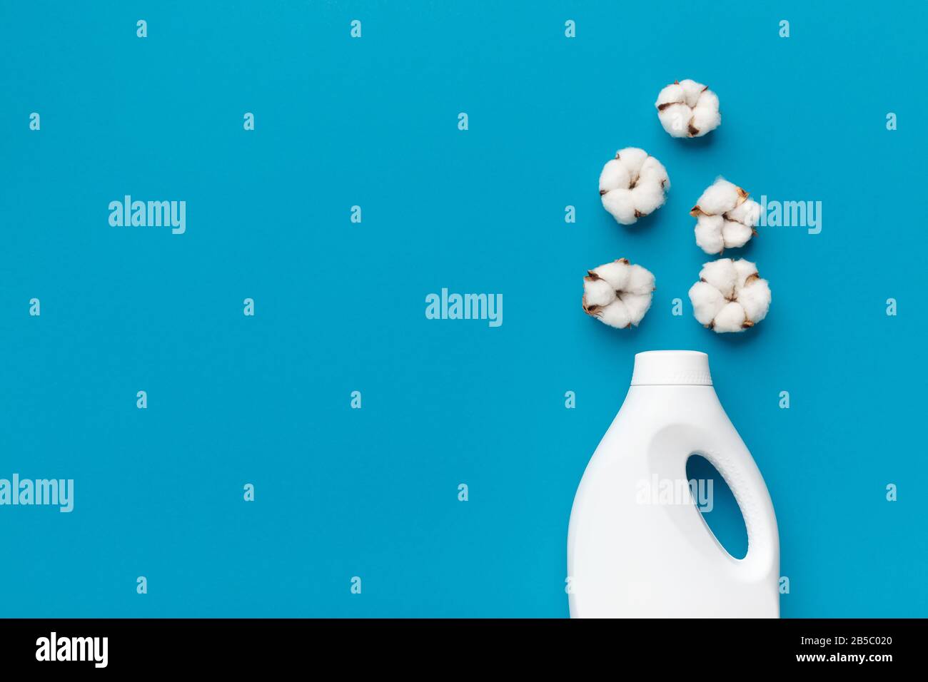 Washing softener for clothes on blue background Stock Photo - Alamy