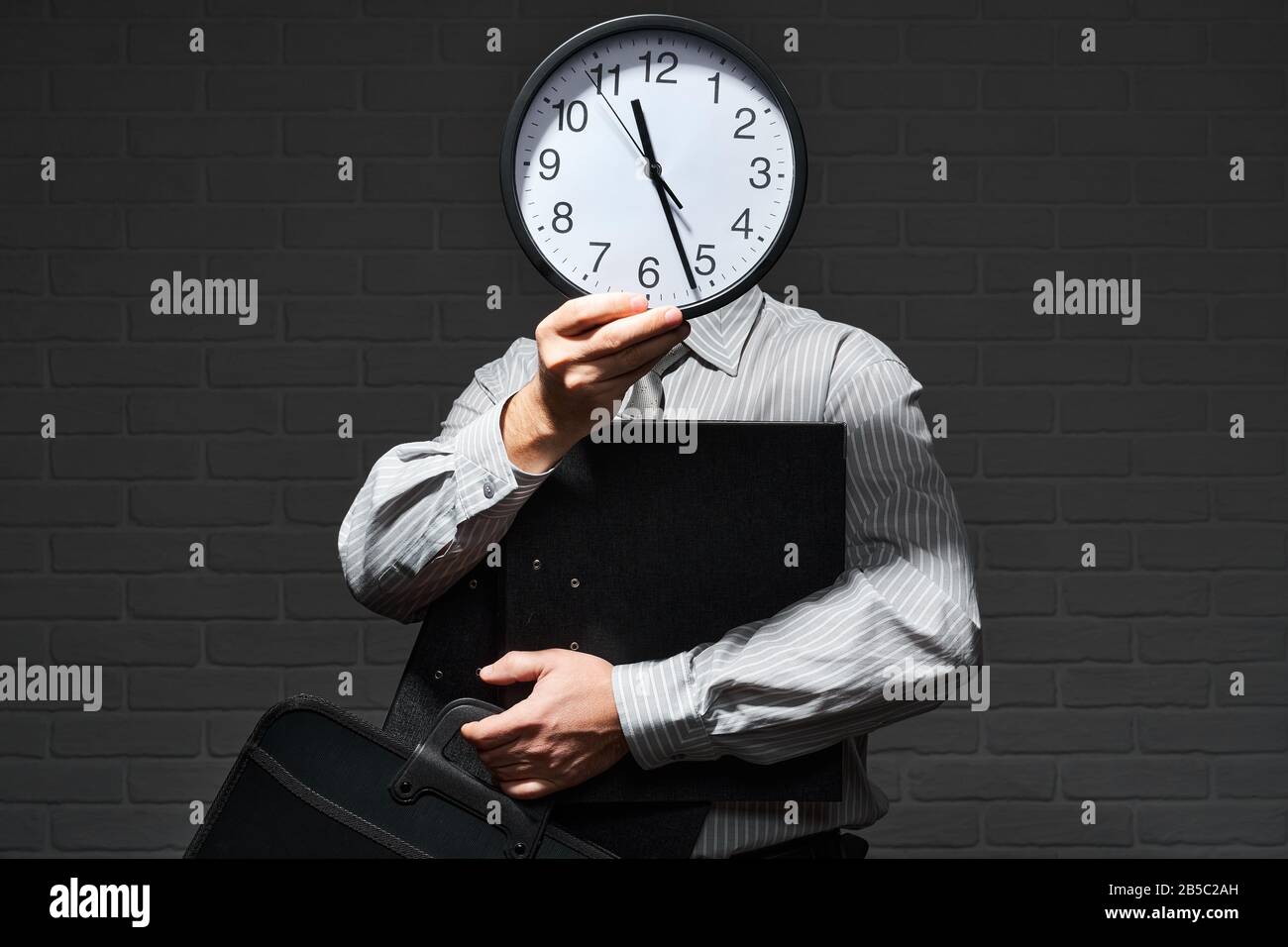 Businessman closeup portrait, he stands and shows the clock in front of ...