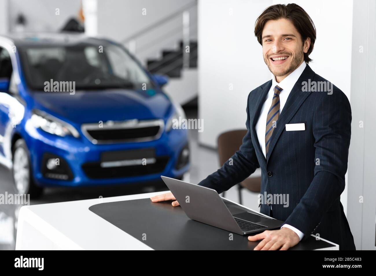 Car Seller Standing In Luxury Dealership Office Stock Photo - Alamy