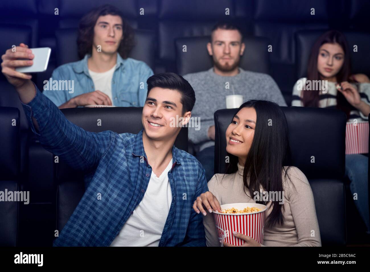 Recreation and leisure. Millennial couple taking selfie on their movie ...