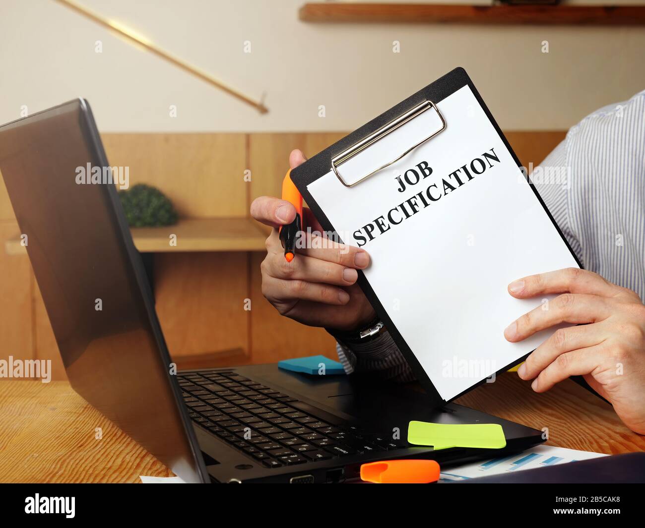 New employee holds job specification papers Stock Photo - Alamy