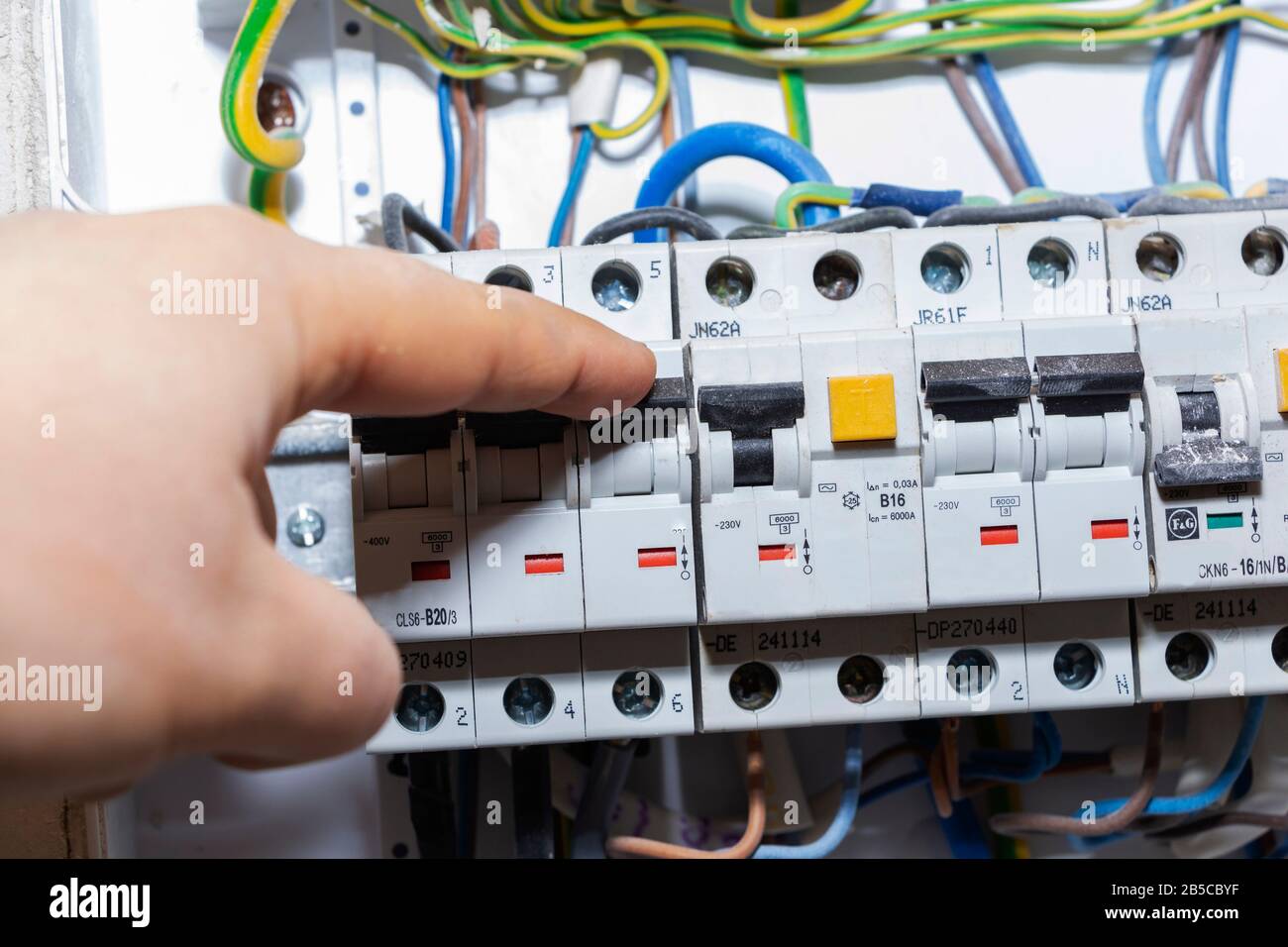 The hand points to a fuse in the power meter. The man disables the ...