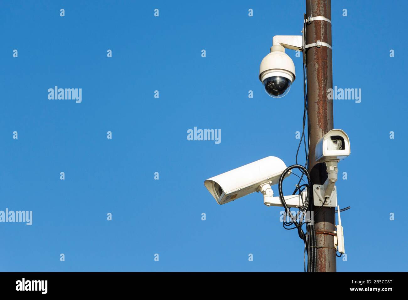 Twin security cameras on a pole against a blue sky Stock Photo - Alamy