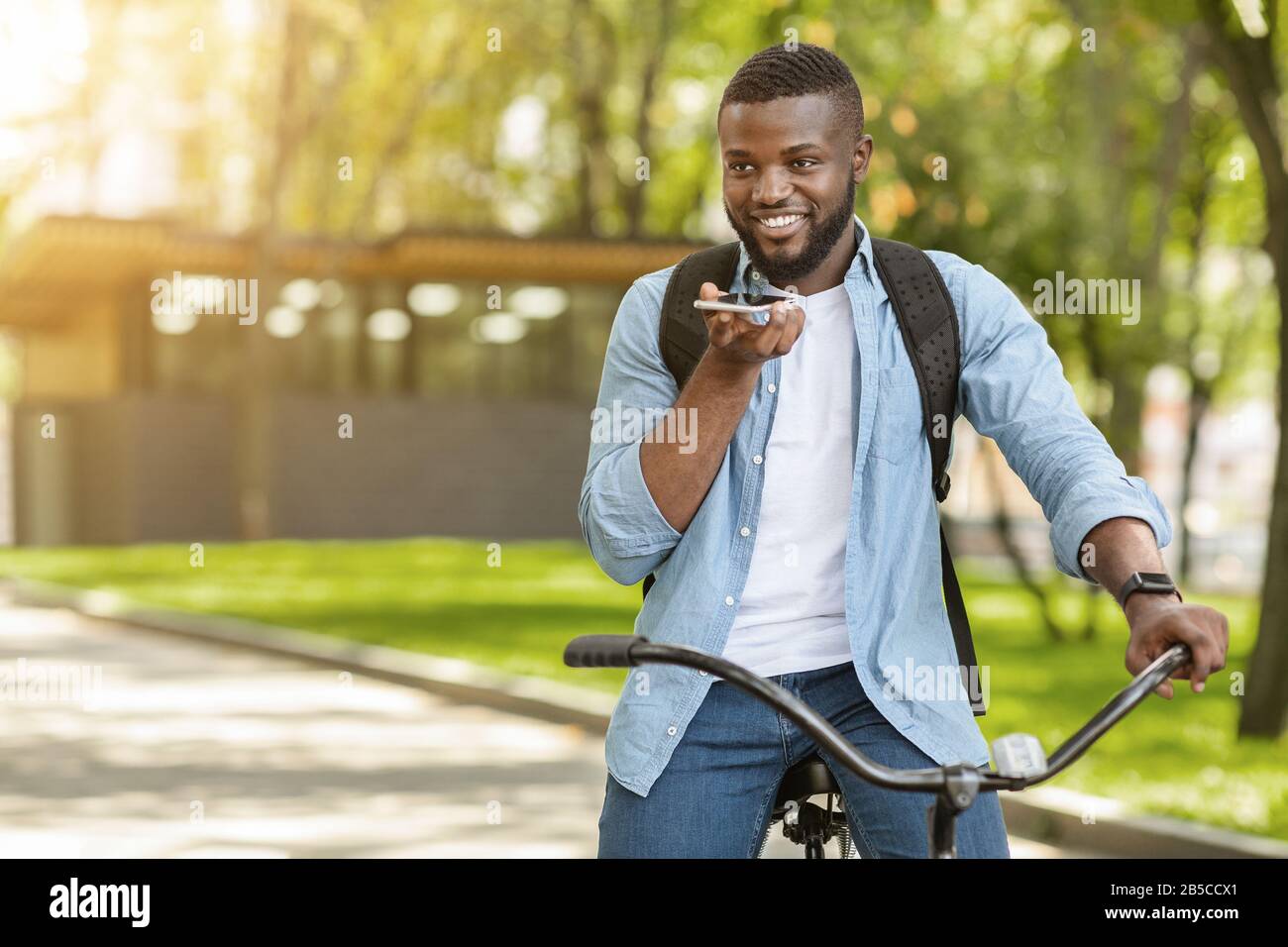 Afro Guy On Bicycle Giving Voice Commands To Smartphone, Opening ...
