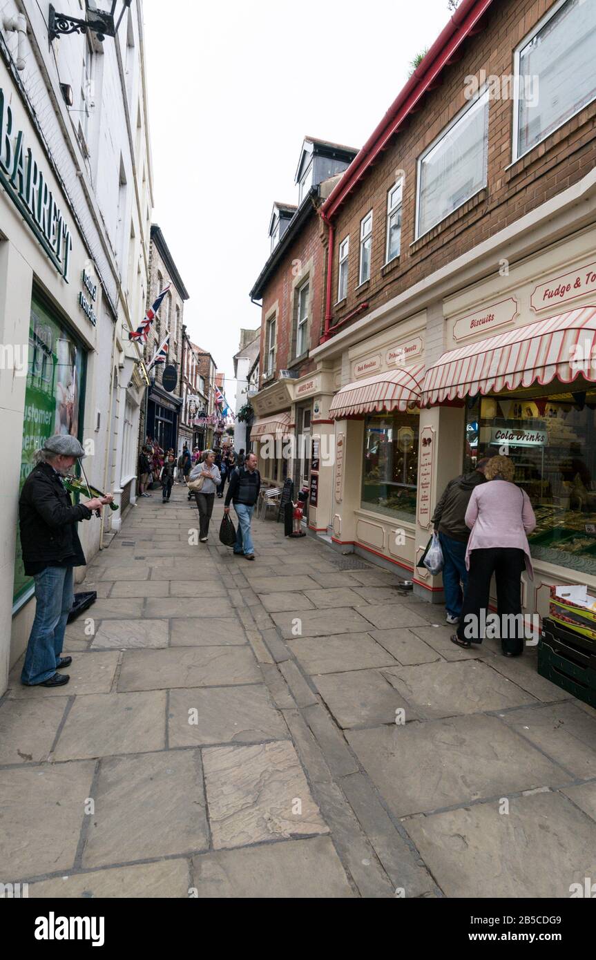 A street busker playing his violin in Sandgate, one of the narrow ...