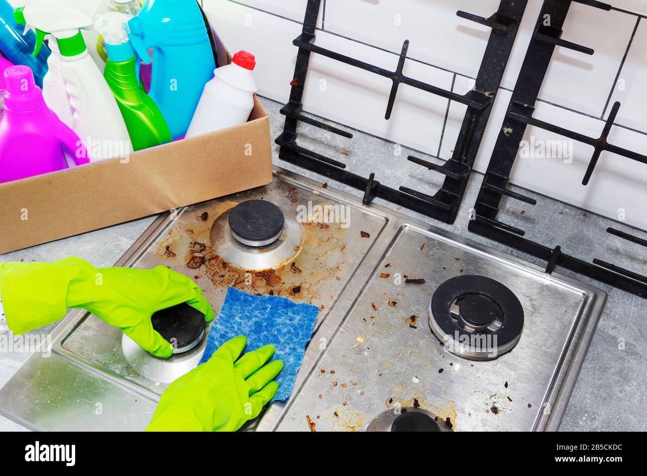Cleaning a gas stove with kitchen utensils, household concepts, or ...