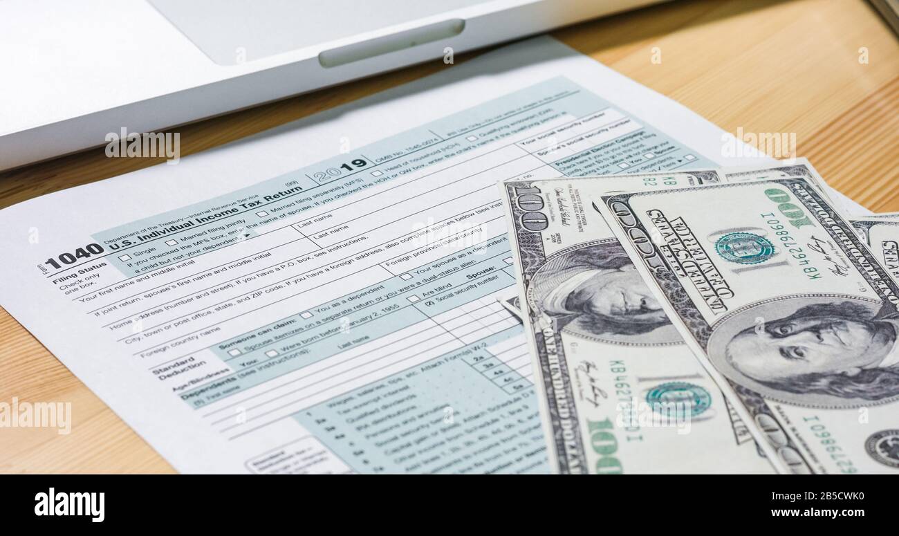 U.S. 1040 tax return form with 100 usd dollar bills Stock Photo - Alamy