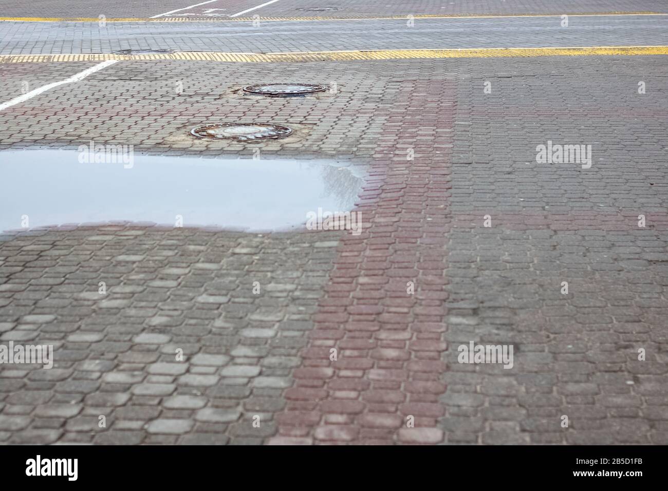 Big puddle on the sidewalk in city Stock Photo - Alamy