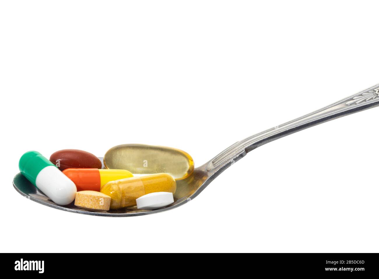 Variety of medical pills and vitamin supplements on a spoon - white ...