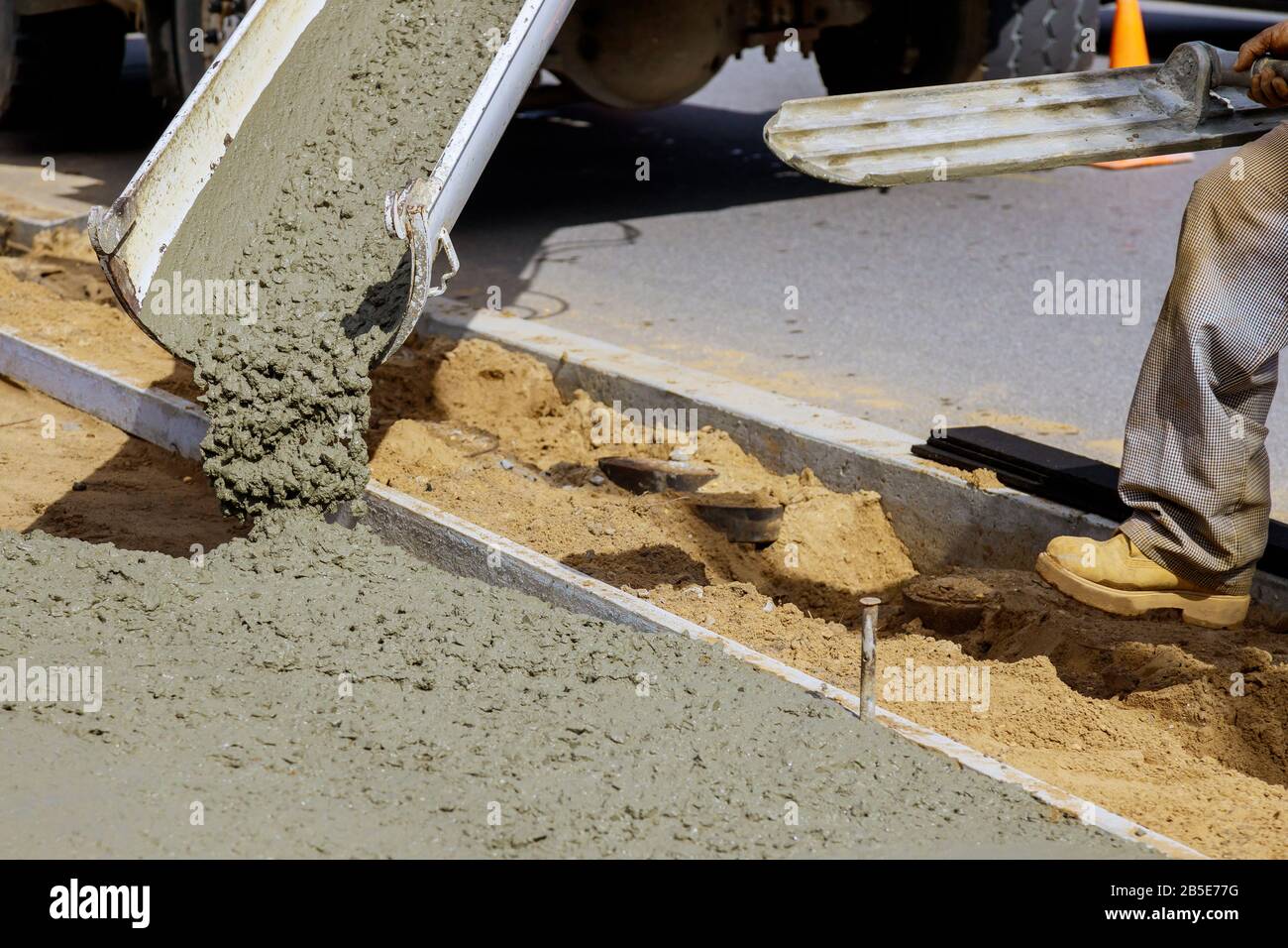Construction worker pour cement for sidewalk in concrete works with ...