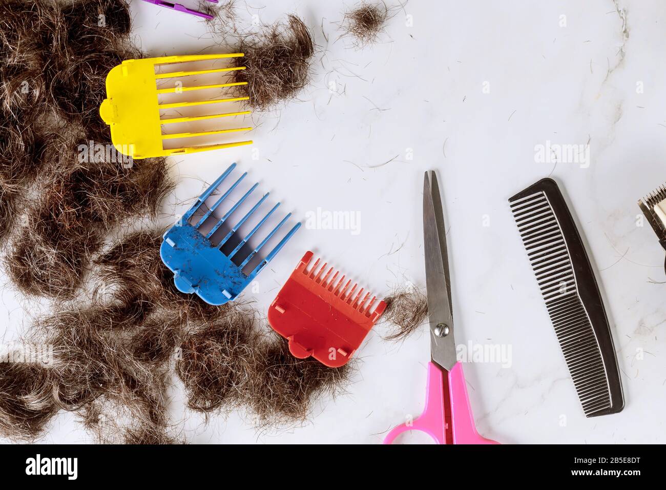 Accesories hair clipper on a trimmed pile of cut hair on a scissors and ...