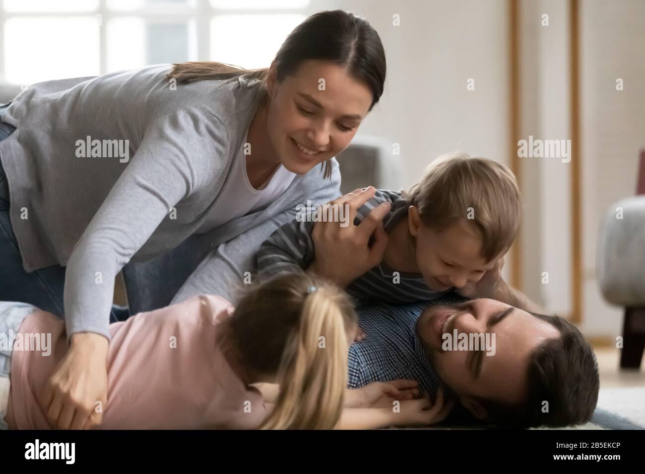 Happy married couple playing with joyful little children Stock Photo ...