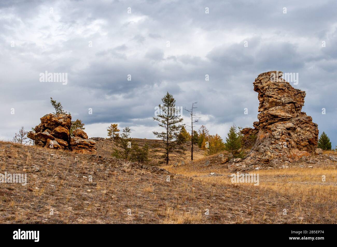 Stone outcrops in the steppe. A gloomy sky with clouds is visible ...