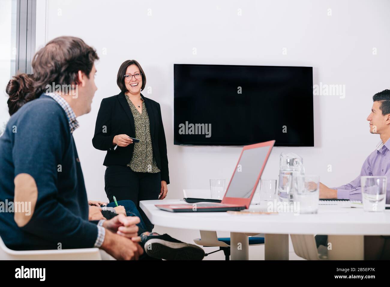 Group of office workers at a meeting around the boss Stock Photo - Alamy