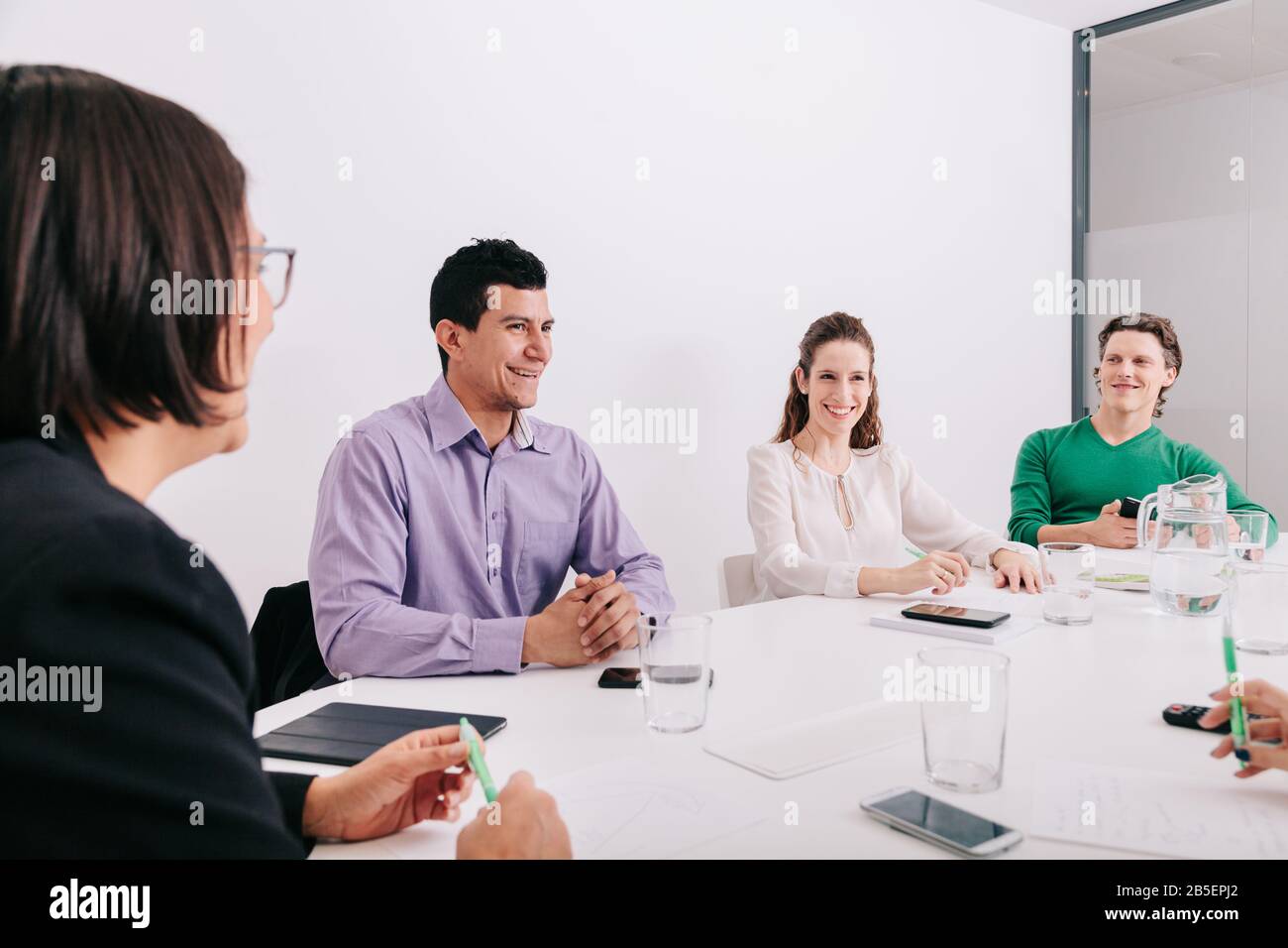 Group of office workers at a meeting around the boss Stock Photo - Alamy