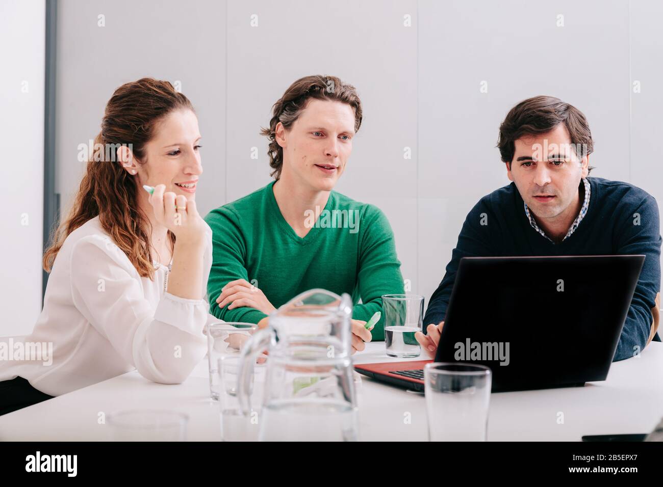 Group of office workers at a meeting around the boss Stock Photo - Alamy