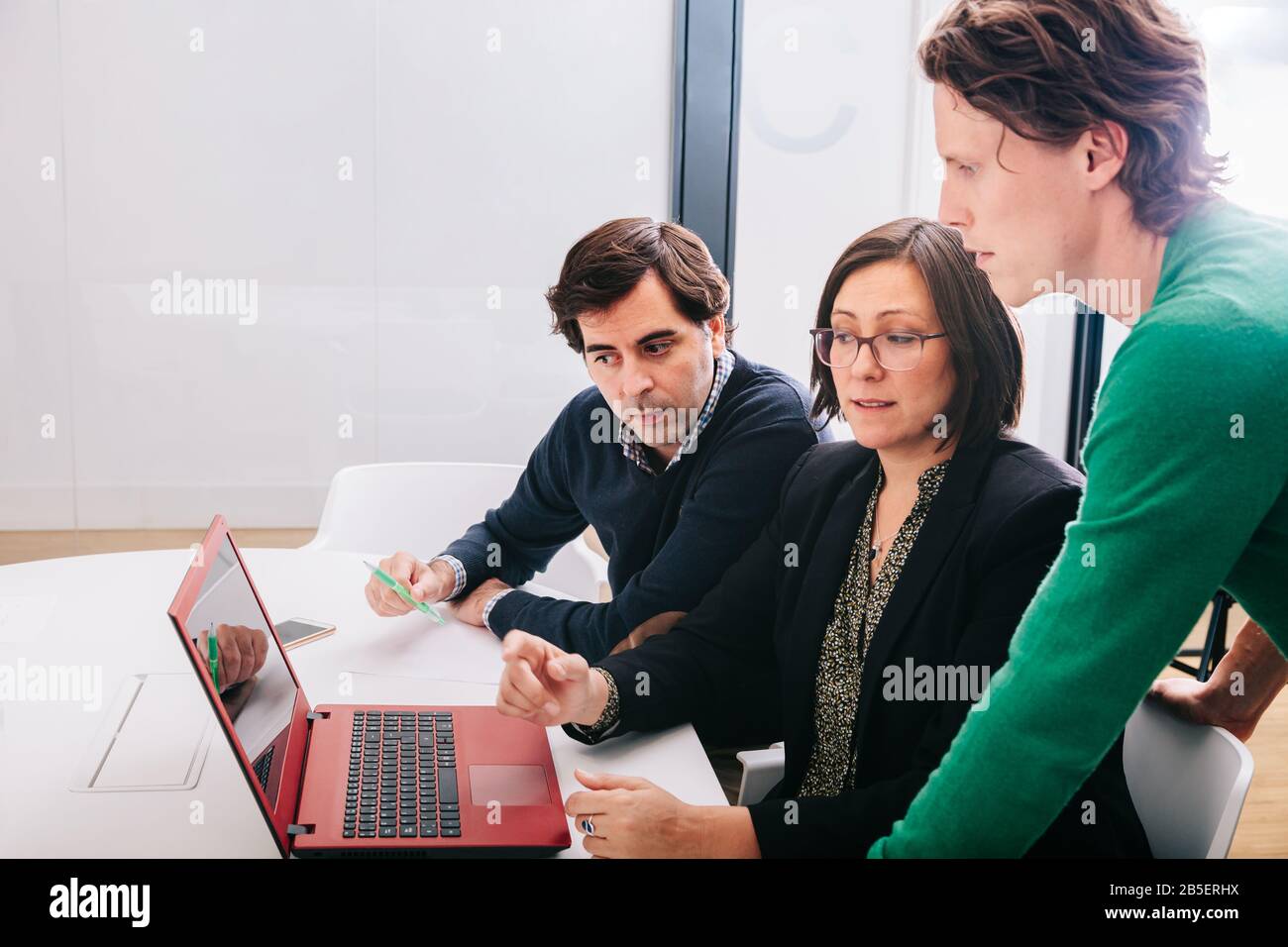 Group of office workers at a meeting around the boss Stock Photo - Alamy