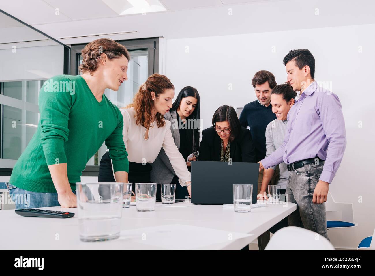 Group of office workers at a meeting around the boss Stock Photo - Alamy