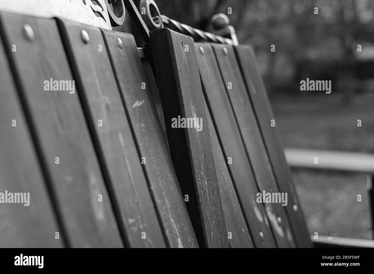 Broken wooden street bench. Park bench with a broken back. Side view ...