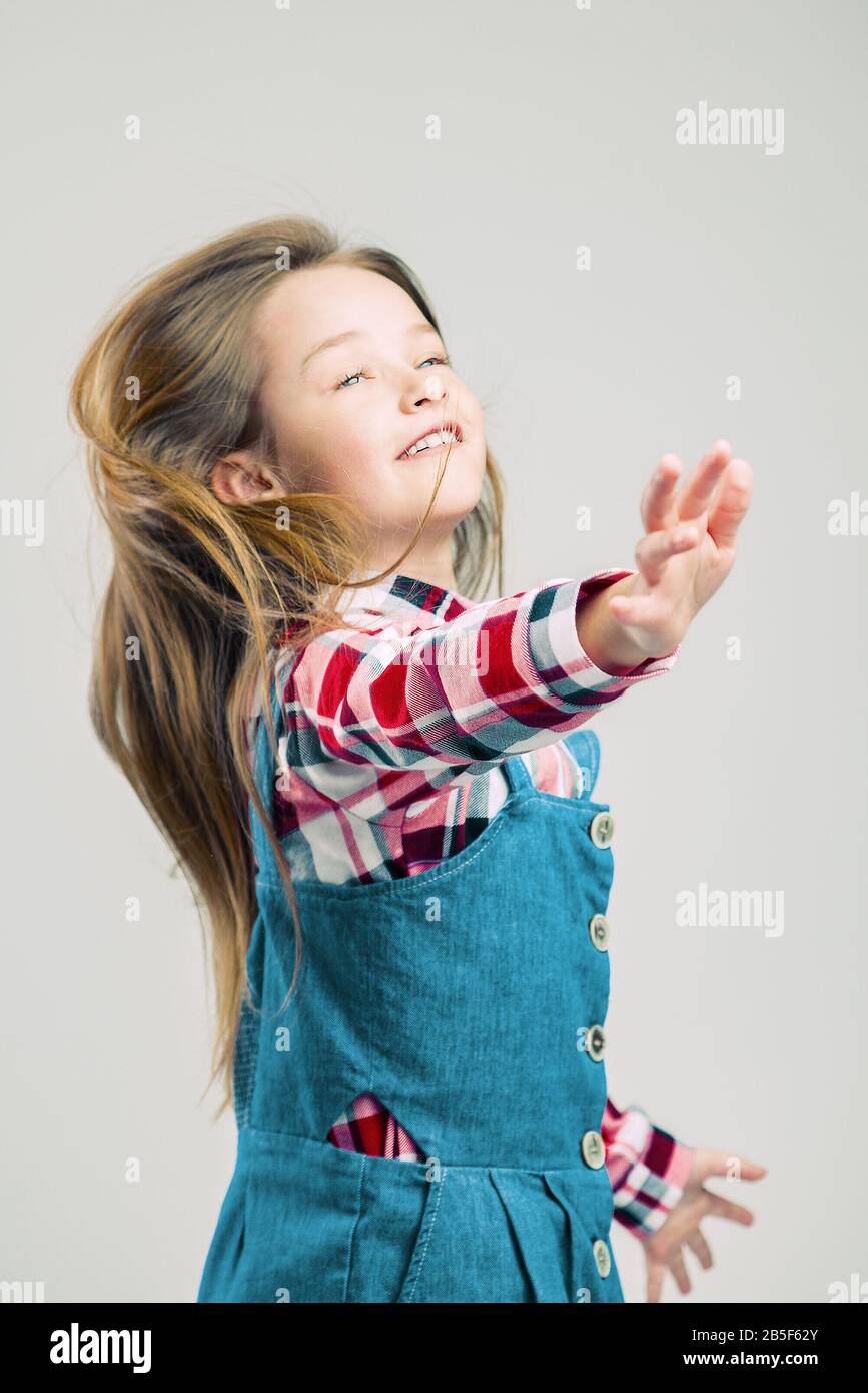 little girl in motion. child with air hairstyle. kid in denim suit and ...