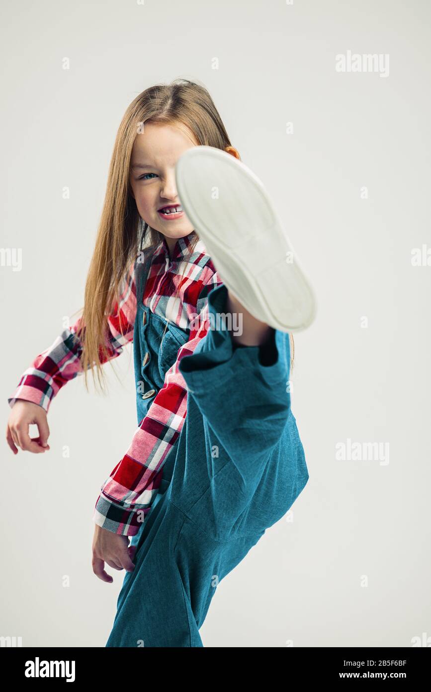 angry little girl kicks. children's fashion studio shooting. kid ...