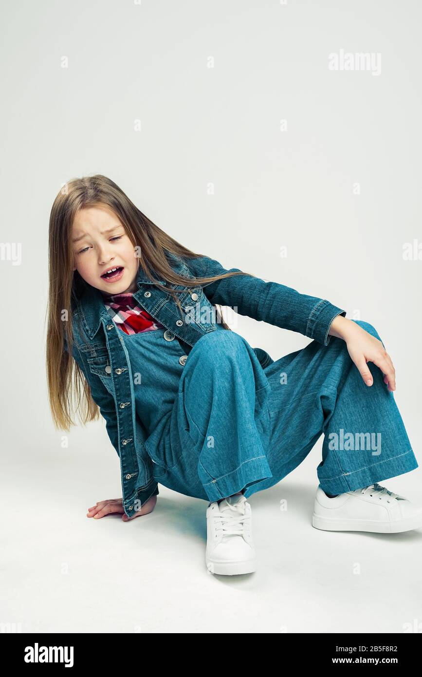 the little girl fell. Kid shows emotion hurt. frustrated child. Studio ...