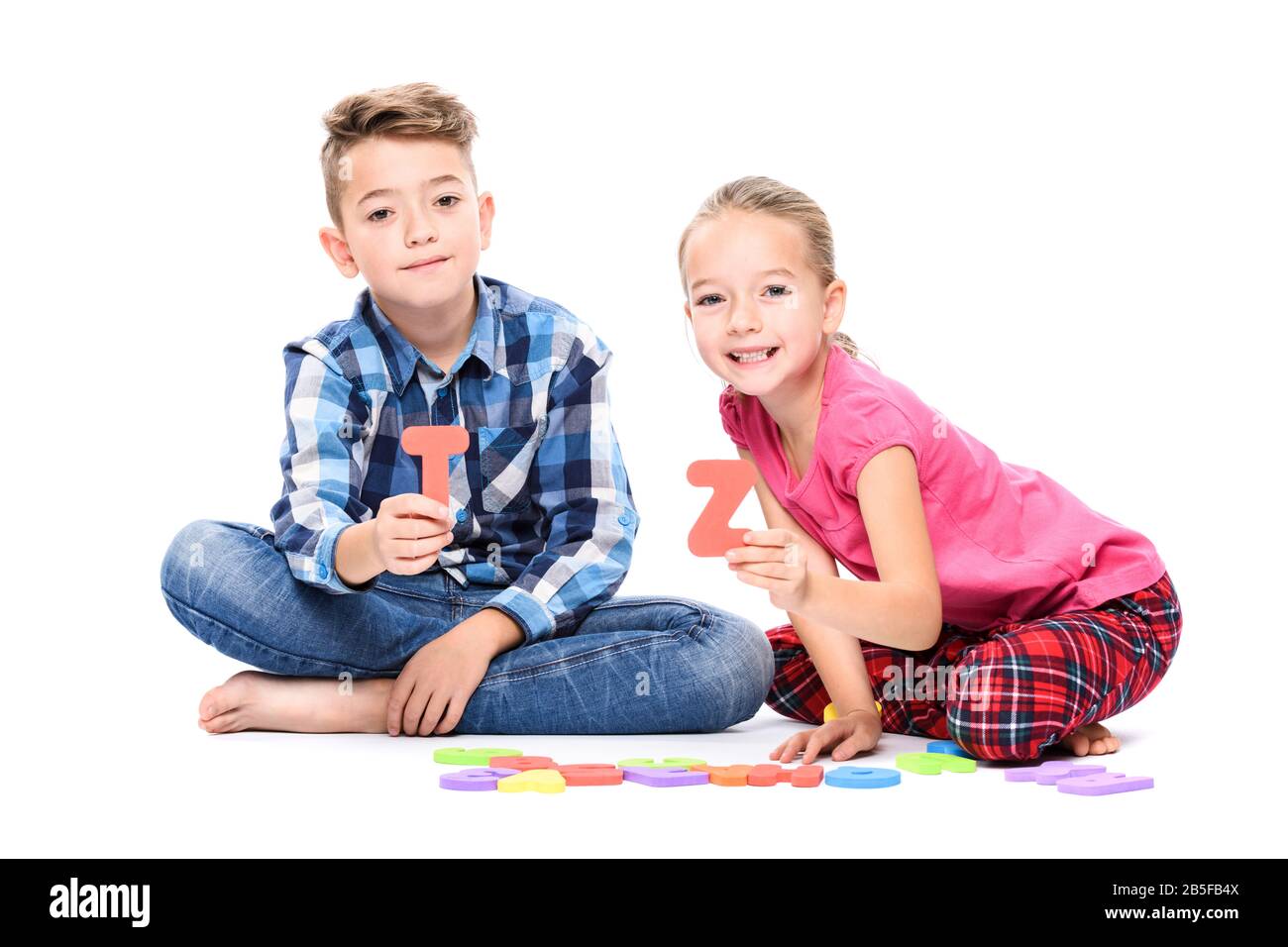 Cute children playing with large colorful alphabet letters on white ...