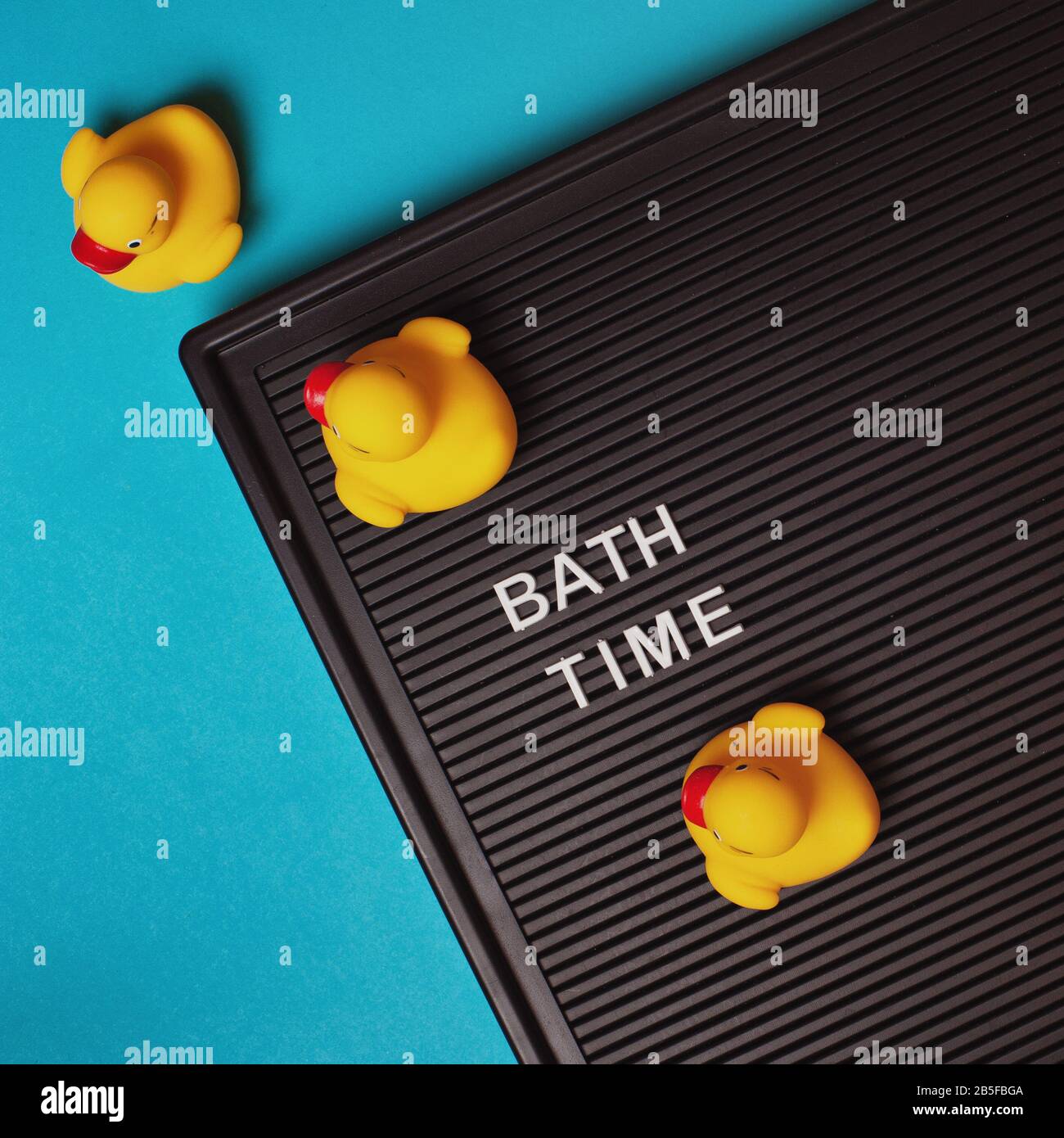 Bath time - text on black letter board with yellow rubber ducks on blue ...