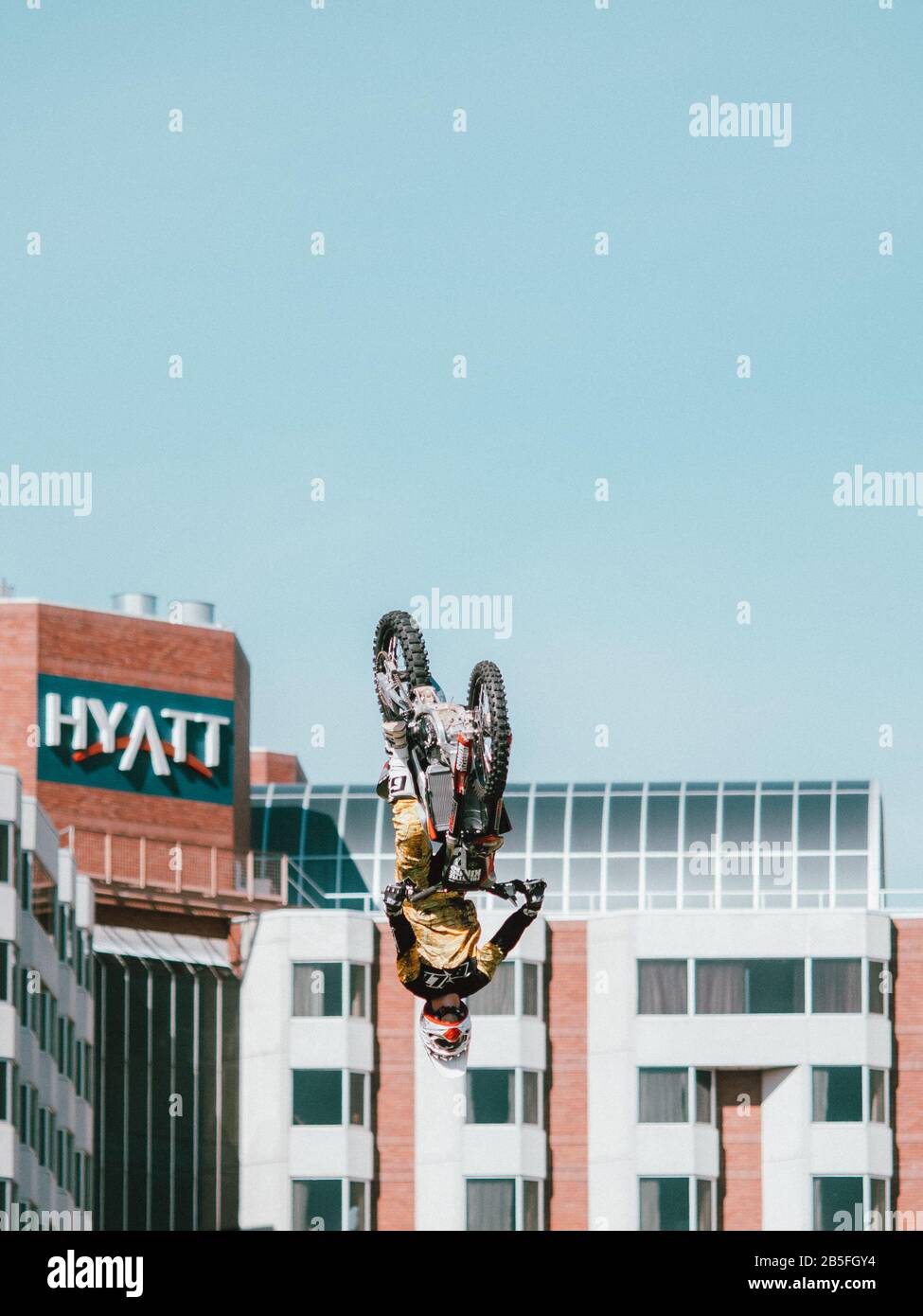 A motorcyclist doing a trick/flip in a city scene in Perth, Australia ...