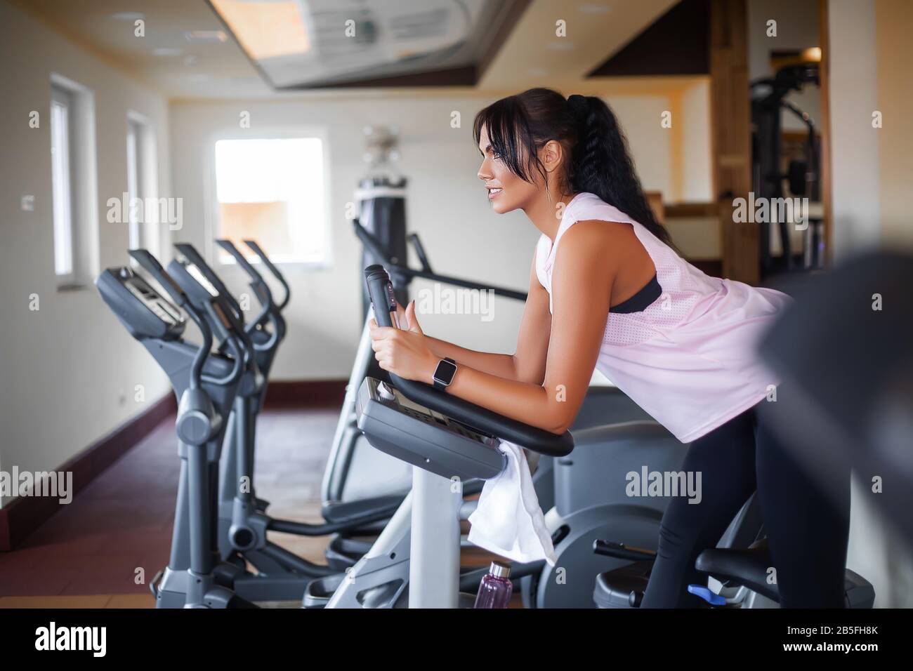 Pretty woman doing physical exercises in gym Stock Photo - Alamy