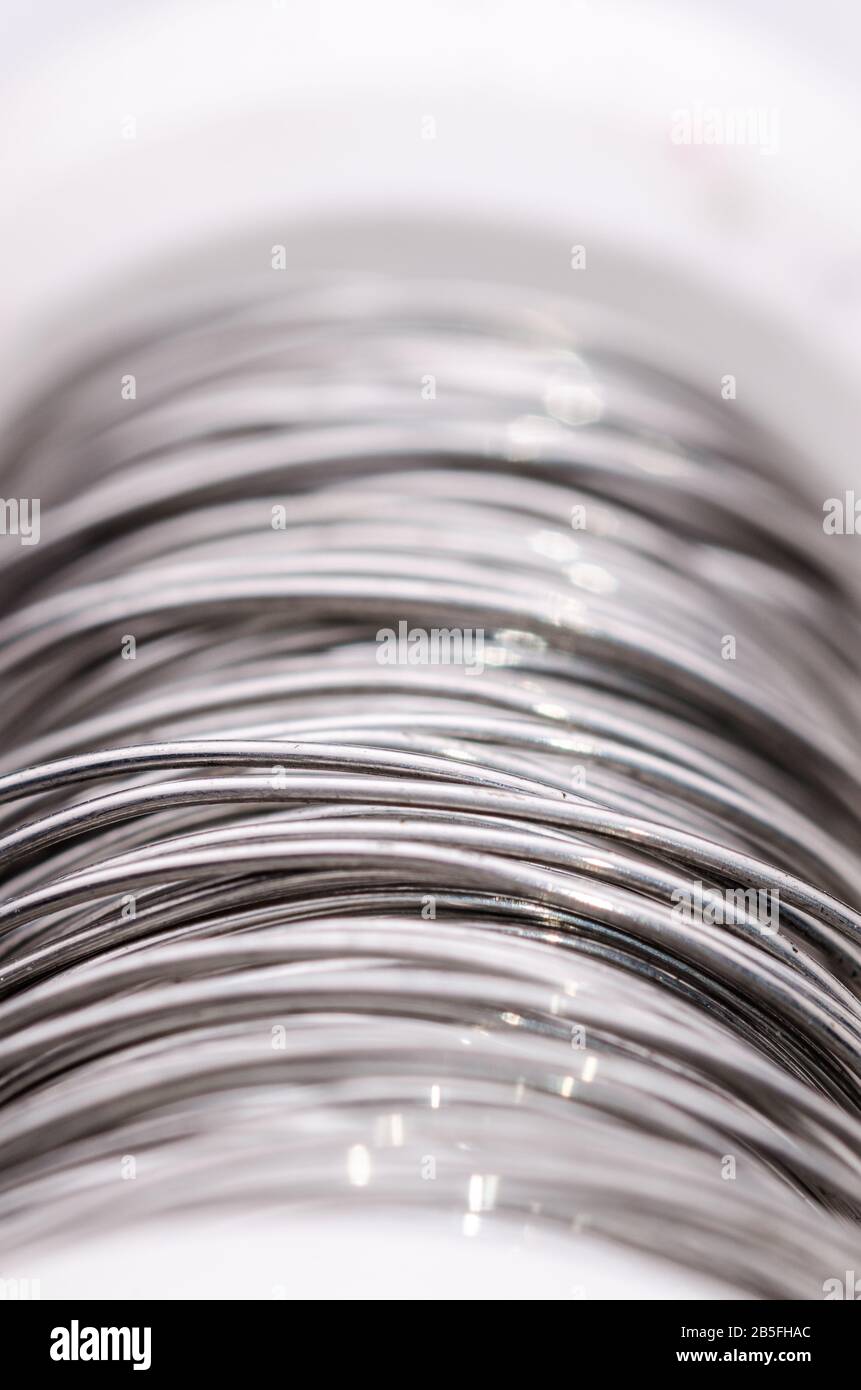 Metal wire on spindle, close up macro still life against white ...