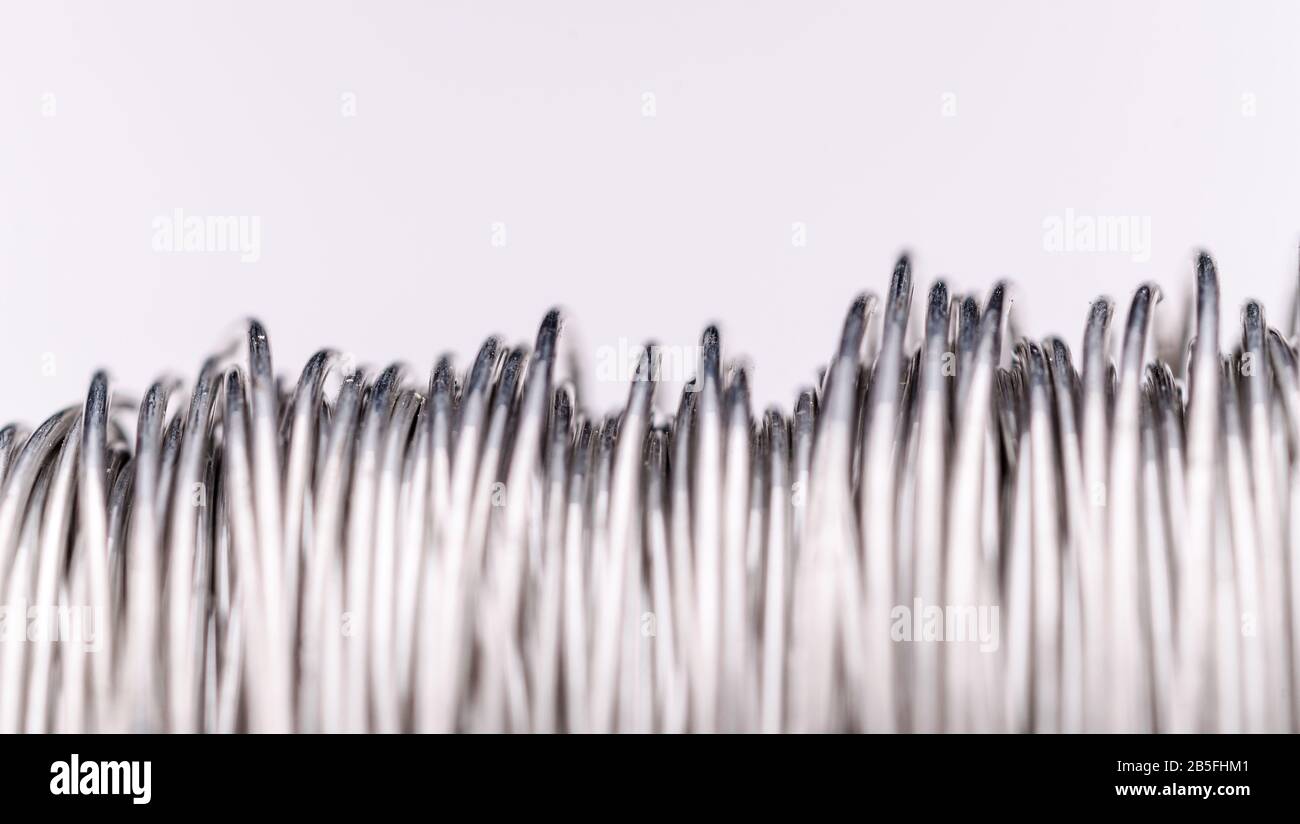 Metal wire on spindle, close up macro still life against white ...