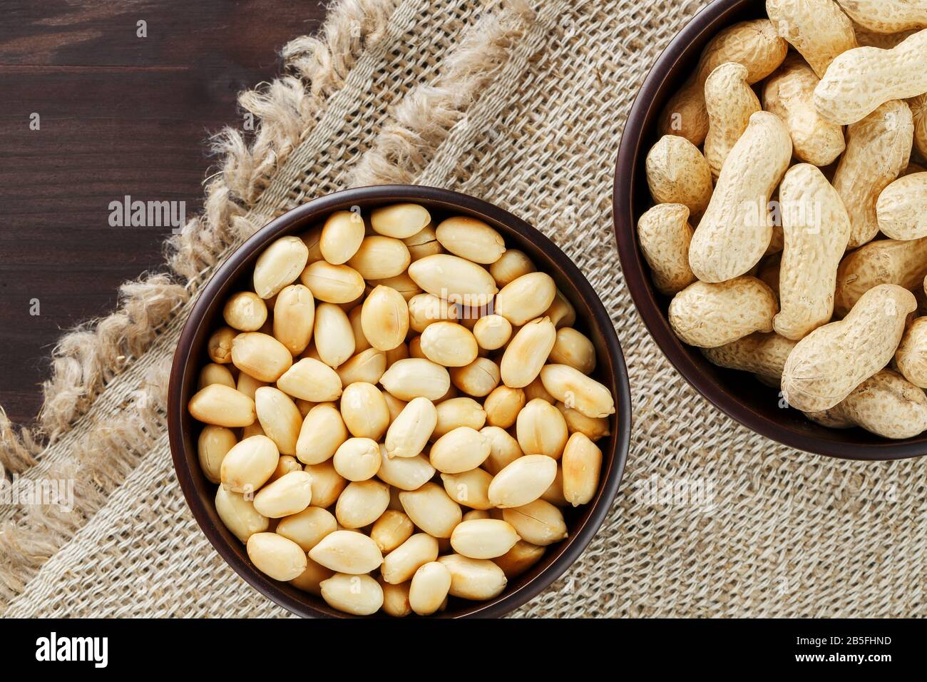 Peanuts in the shell and peeled close up in a cup. Background with ...