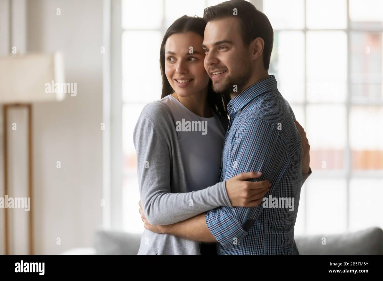 Loving affectionate married couple cuddling, looking away Stock Photo ...
